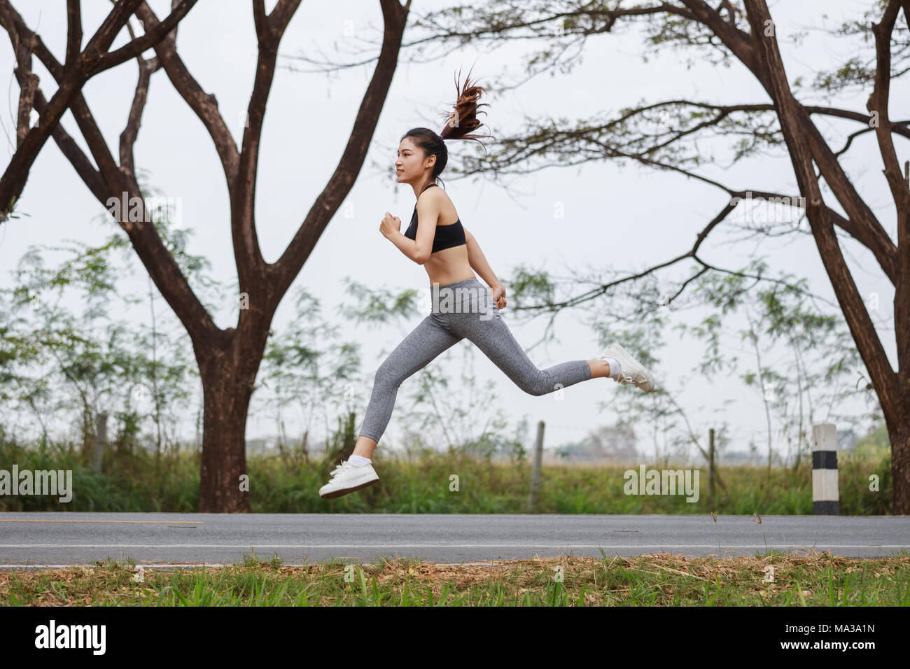 sporty woman running and jumping in the park Stock Photo - Alamy