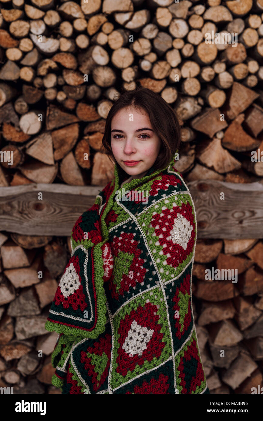 young woman wrapped in a blanket in front of a woodpile,portrait Stock ...