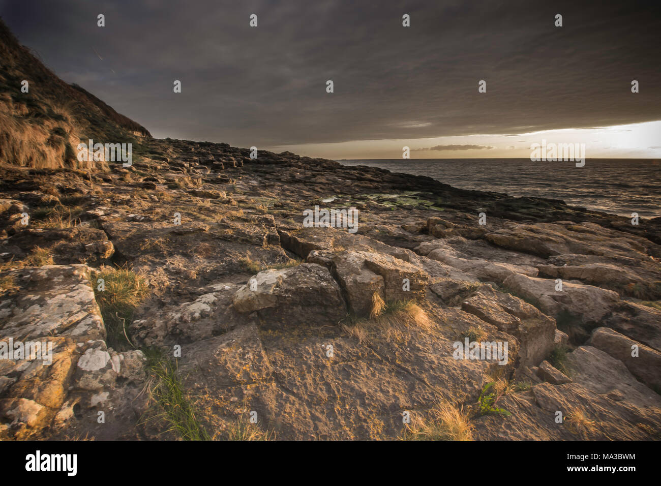 Sunset on rocky beach in Moelfre.Stunning landscape of Anglesey island ...
