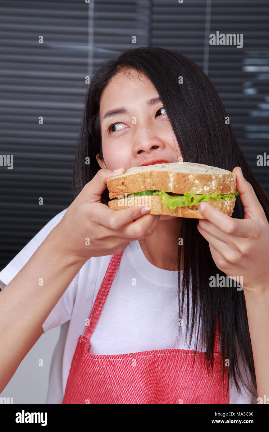 woman eating a sandwich in kitchen room at home Stock Photo - Alamy