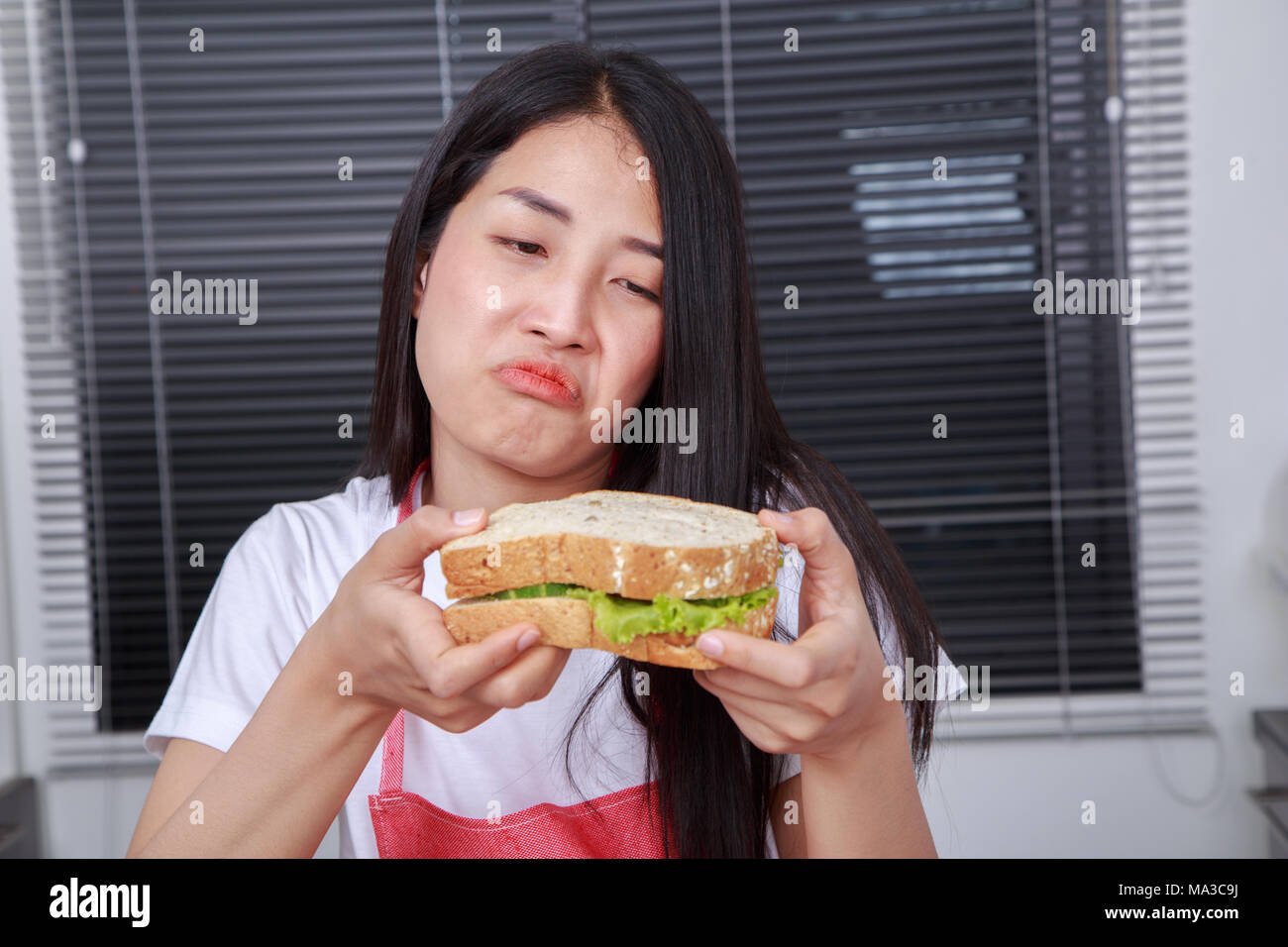 woman with a sandwich in kitchen room at home Stock Photo - Alamy