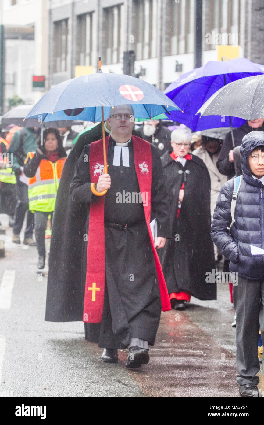 London, UK. 30th March 2018. A cross bearer leads a procession of ...
