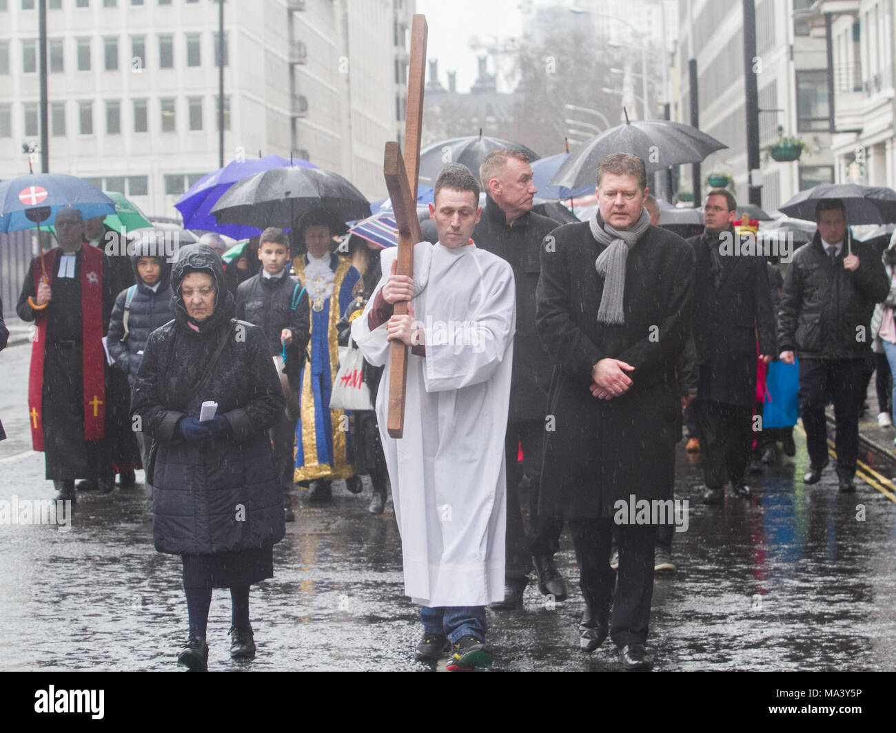 London, UK. 30th March 2018. A cross bearer leads a procession of ...
