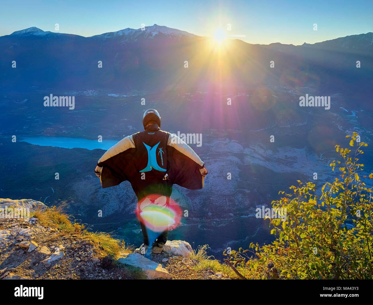 A base jumper wearing a wingsuit and about to jump from Monte Brento in ...