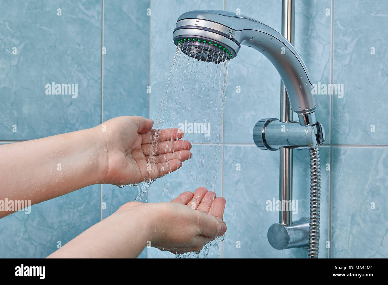Two human palms under stream of water from handheld shower with glide ...