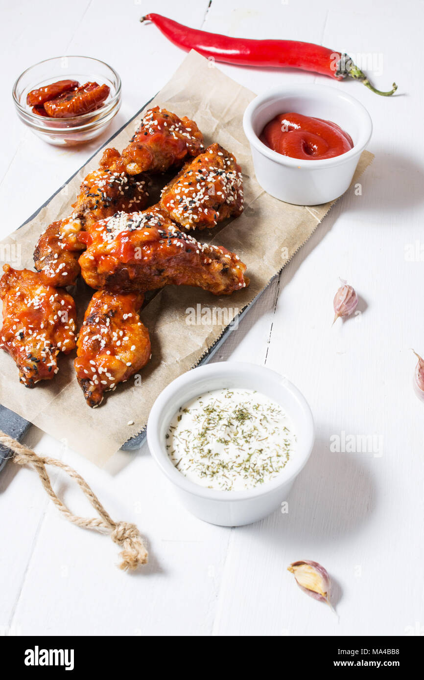 Baked chicken wings with sauce on white wood background Stock Photo - Alamy