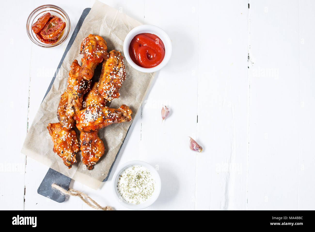 Baked chicken wings with sauce on white wood background . Copy space ...