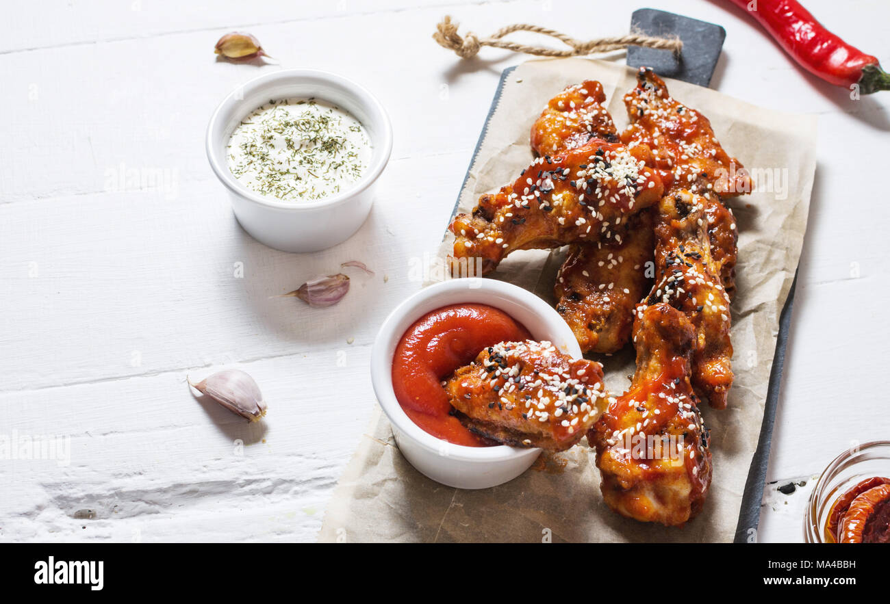Baked chicken wings with sauce on white wood background Stock Photo - Alamy