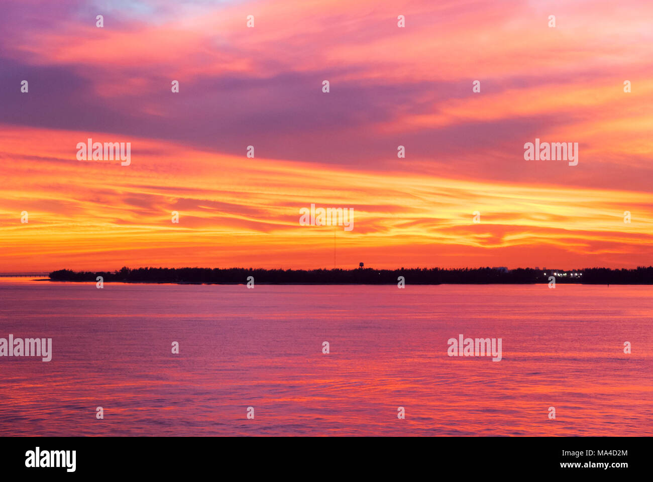 The colorful ocean and the sky lit by sunset outside the city of Miami ...