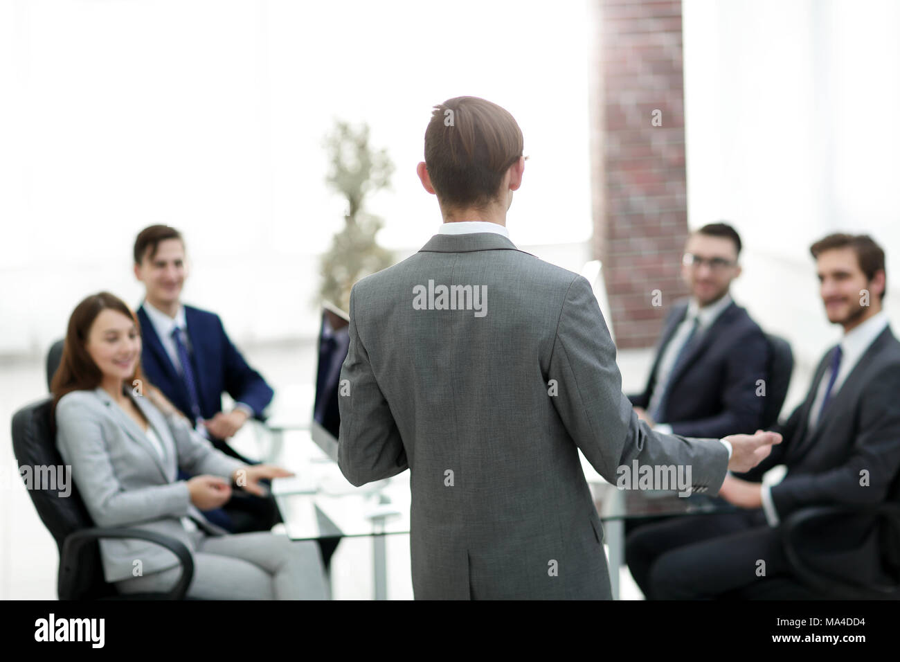 Rear view portrait of man giving business presentation to colleagues in ...