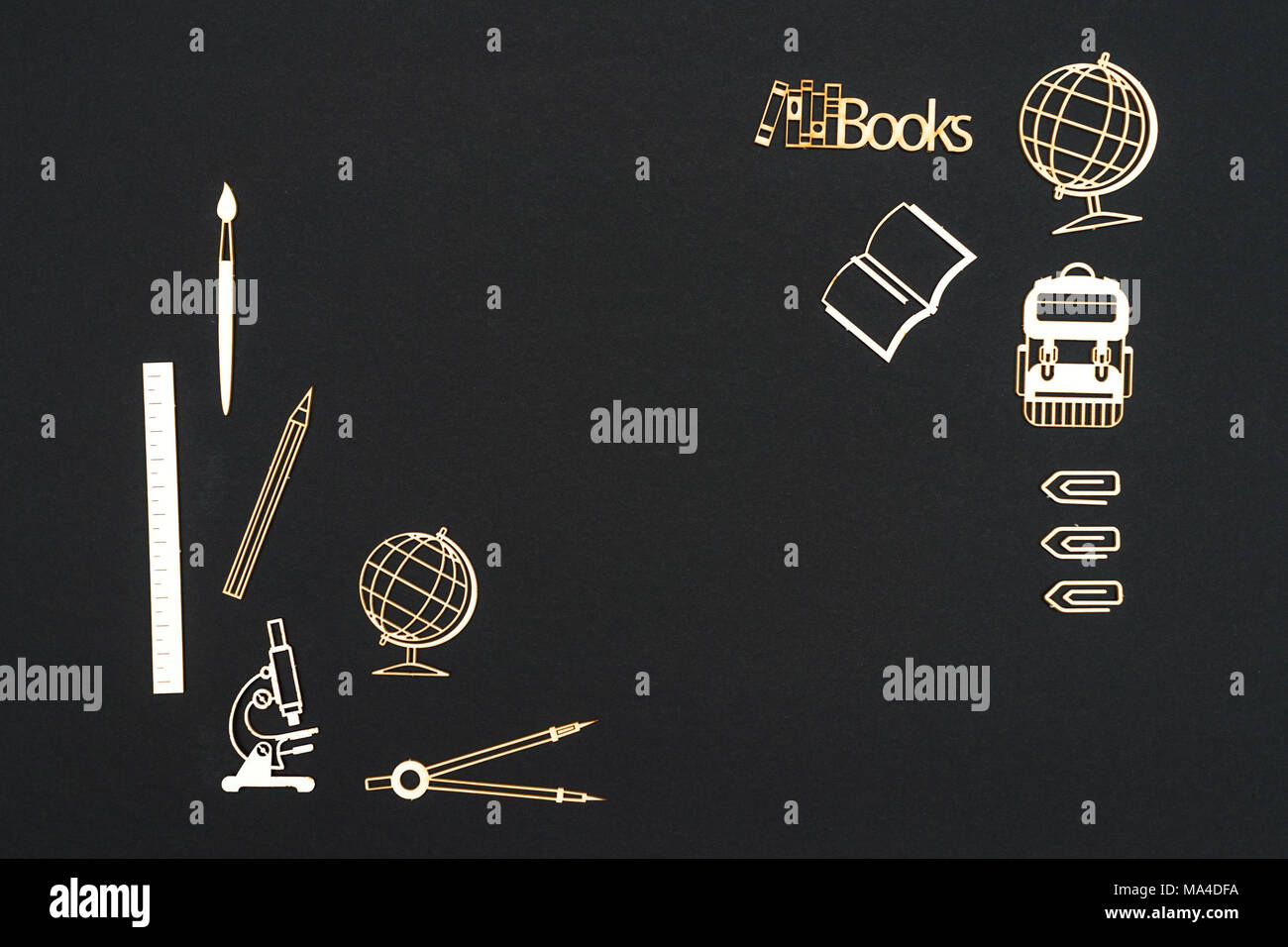 Wooden chipboard miniatures school supplies placed on blackboard ...