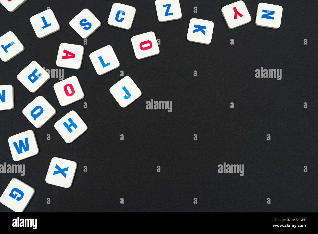 English colored square letters scattered on black background. English ...