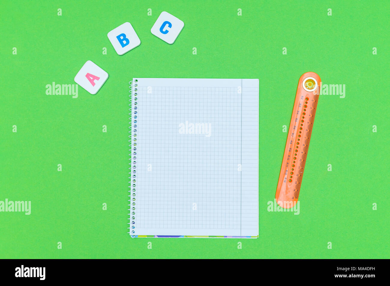 Letter blocks alphabet ABC with notebook and ruler on green background ...