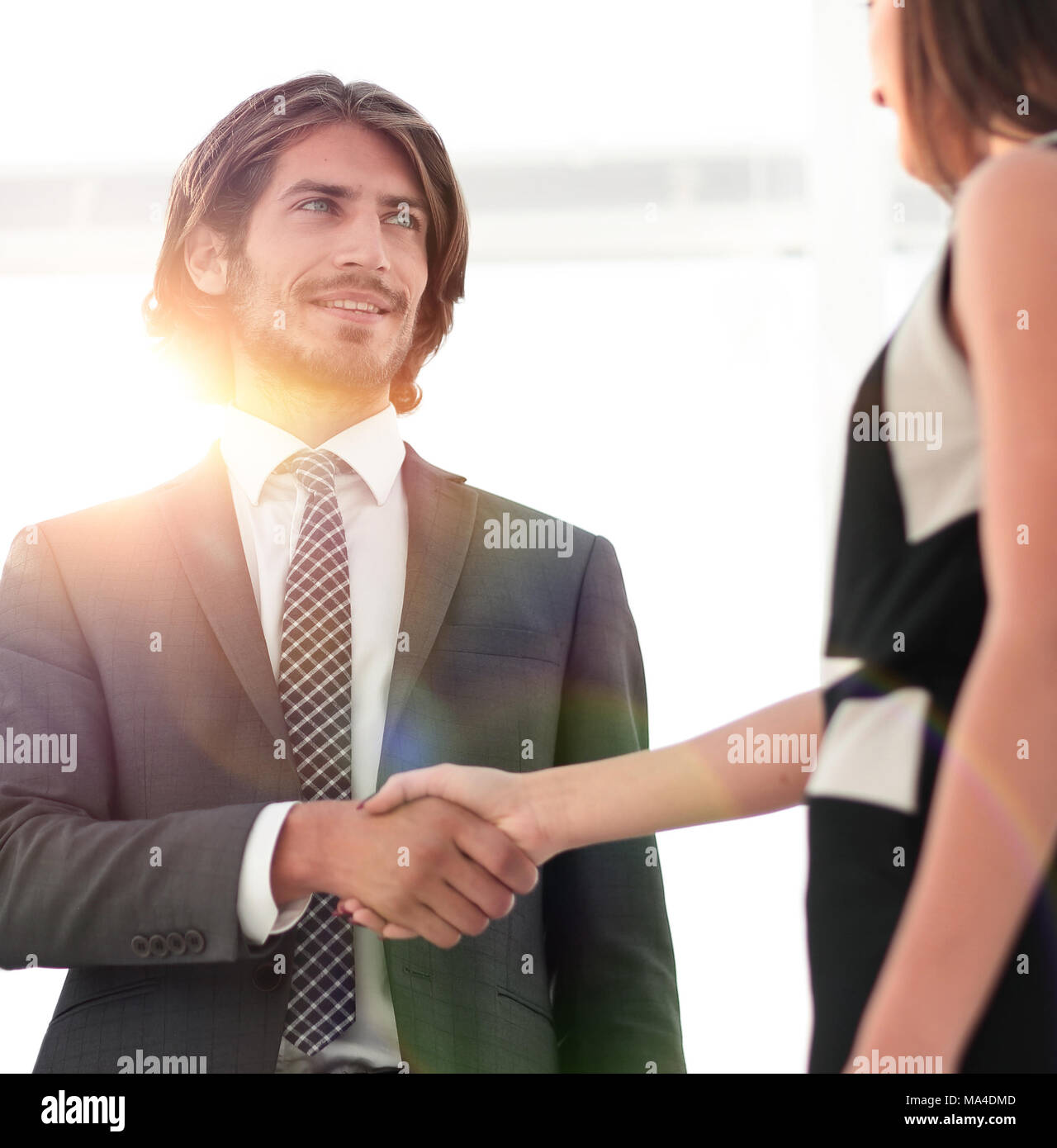 Business partners handshaking over business objects on workplace Stock Photo - Alamy