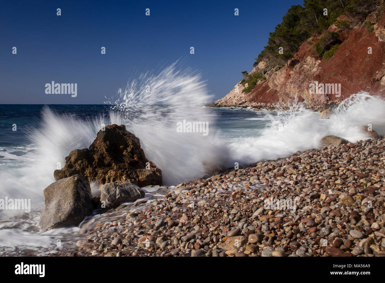 Wave breaking on a rock on the beach at Port de Valldemossa, Mallorca ...