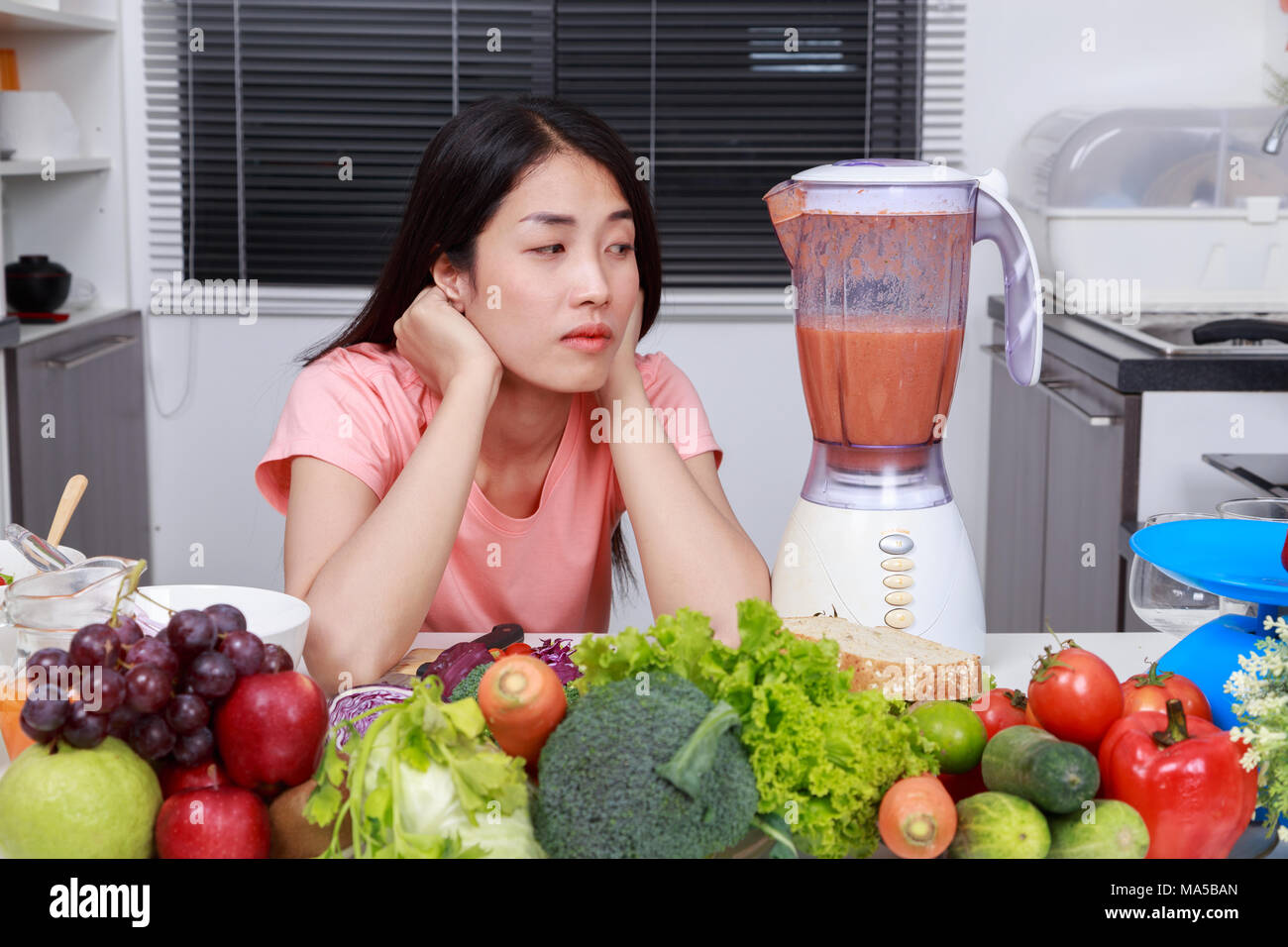 young woman making smoothies with blender in kitchen Stock Photo - Alamy