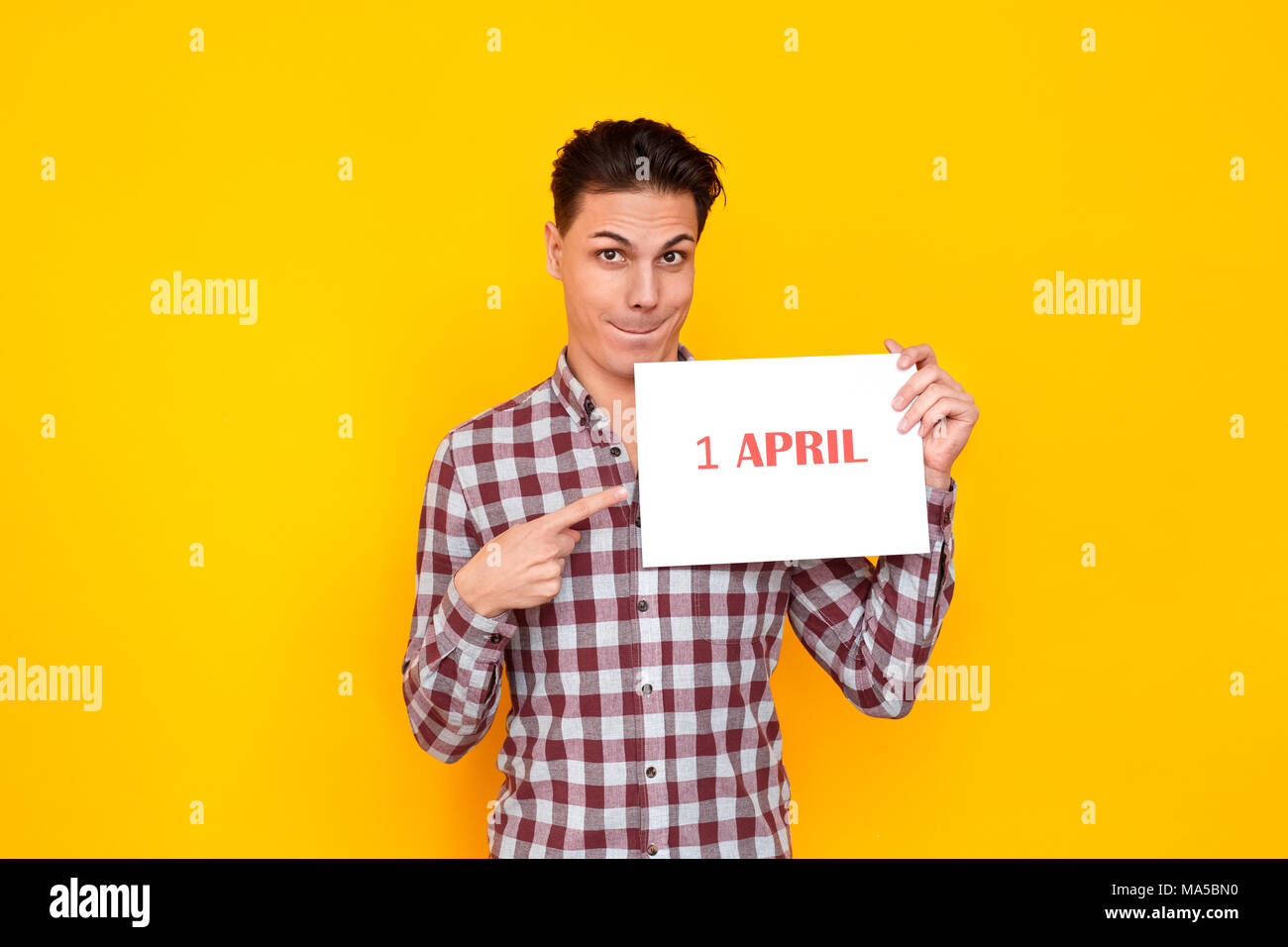 Playful man holding prank table with an inscription 1 april. Fool's day ...