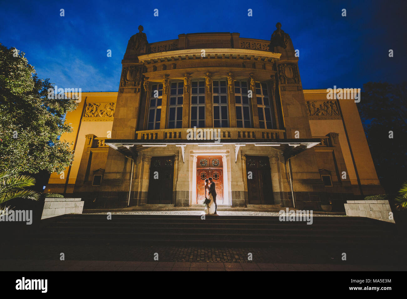 Bridal couple, hug, building, entrance, lights, evening Stock Photo - Alamy