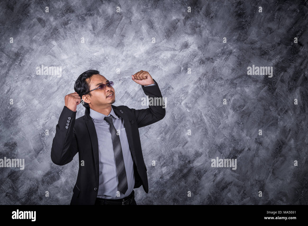 young winner business man in suit with arms raised Stock Photo - Alamy