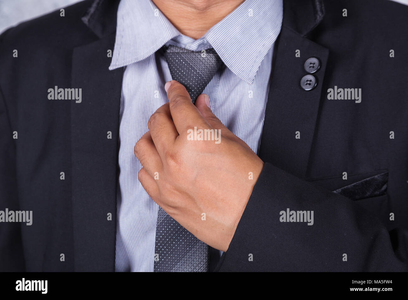 Man adjusting necktie hi-res stock photography and images - Alamy