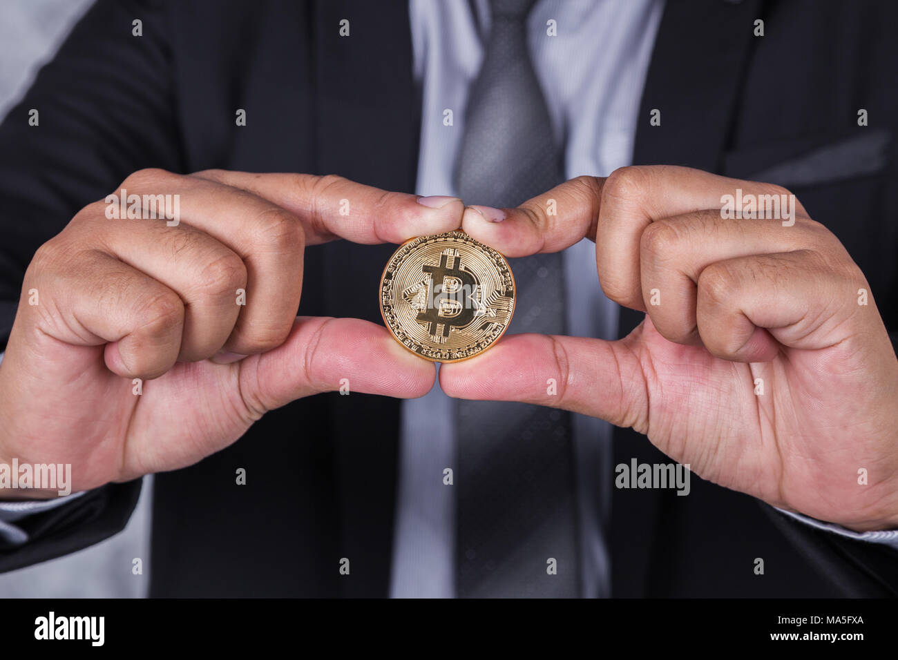 bitcoin in hand of business man with suit Stock Photo - Alamy