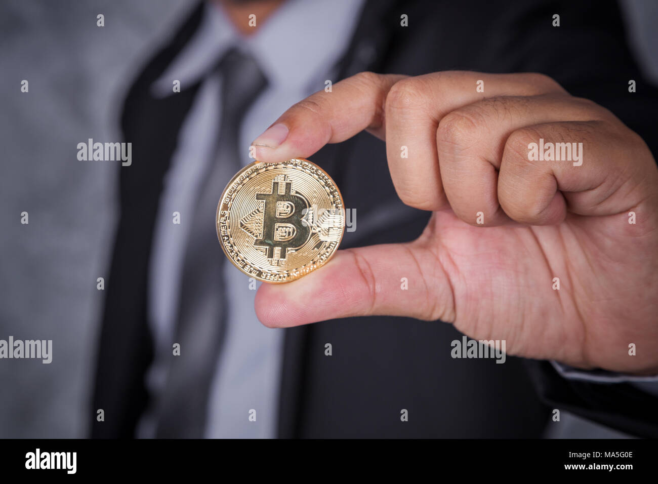 bitcoin in hand of business man with suit Stock Photo - Alamy