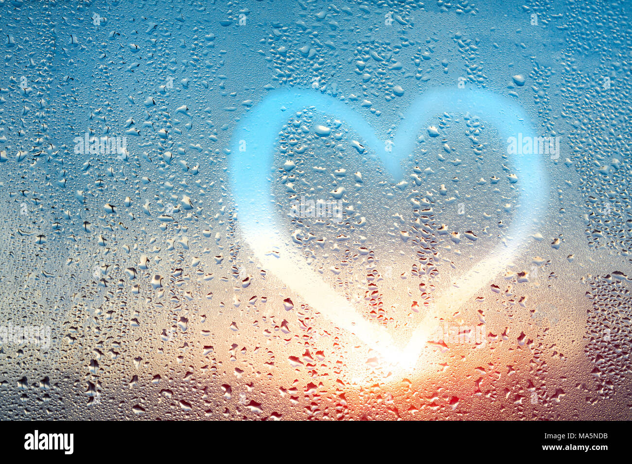 image of a heart and a question mark on a wet misted window. Emotion of ...