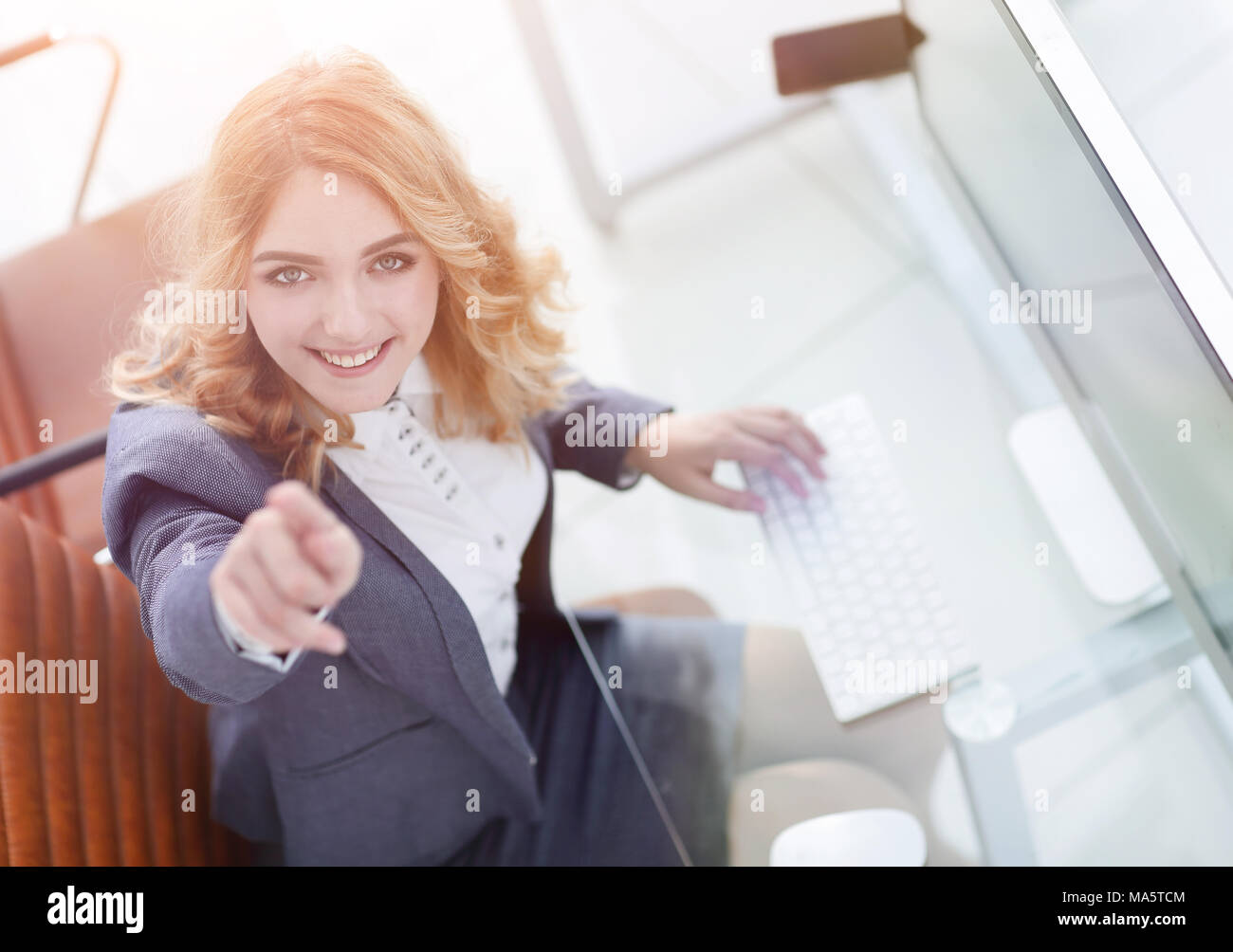 business woman pointing forward,sitting behind a Desk .photo with copy ...