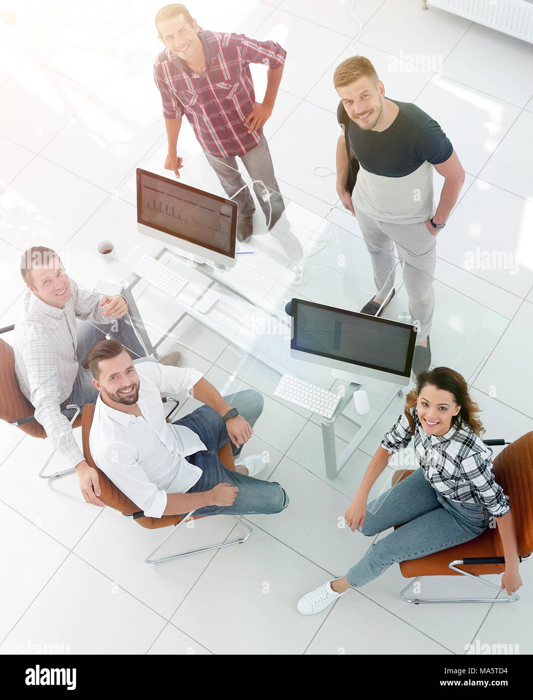 view the top creative team sitting behind a Desk and looking at camera ...