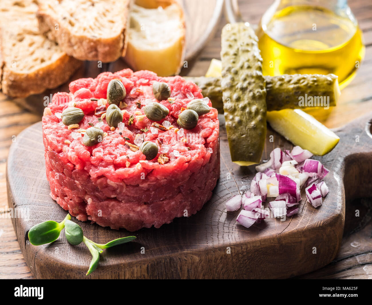 Steak tartare served with capers, pickled cucumbers and chopped onion ...