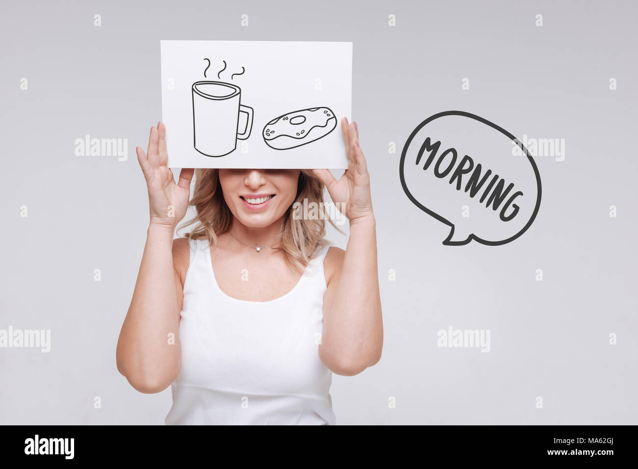 Optimistic woman smiling and starting her morning with tasty coffee ...