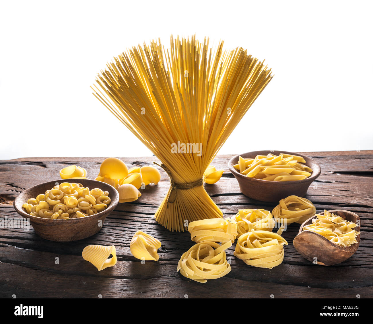 Different pasta types on wooden table. White background Stock Photo - Alamy