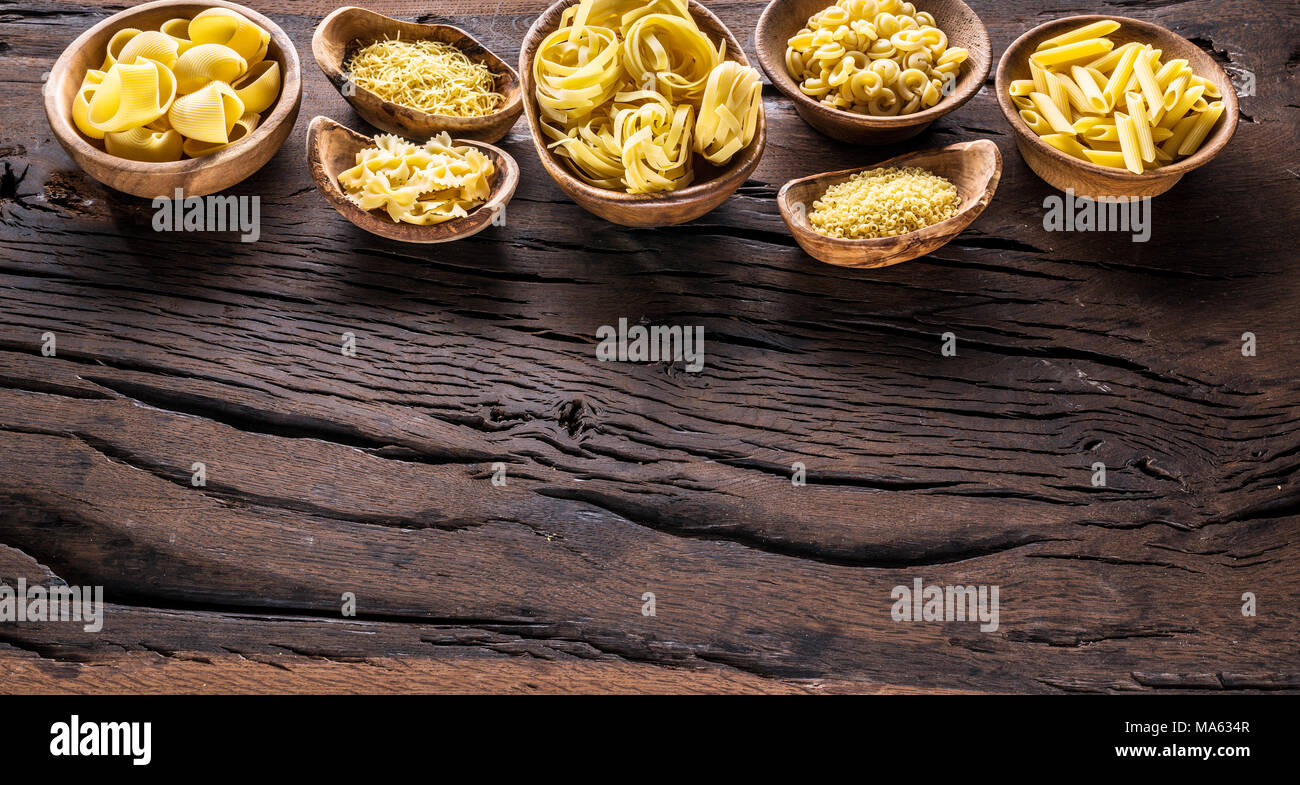 Different pasta types in wooden bowls on the table. Top view Stock ...
