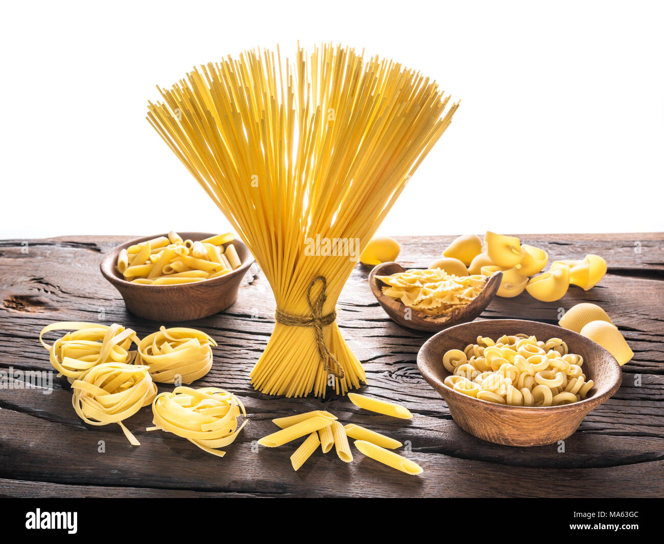 Different pasta types on wooden table. White background Stock Photo - Alamy