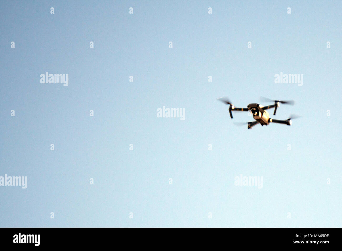 Drone flying overhead in cloudy blue sky Stock Photo - Alamy