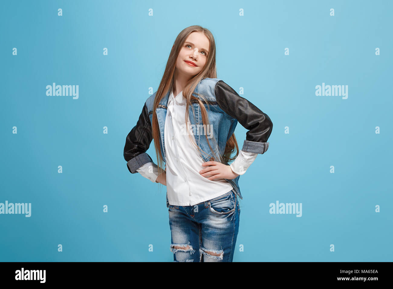 The happy teen girl standing and smiling against blue background Stock ...