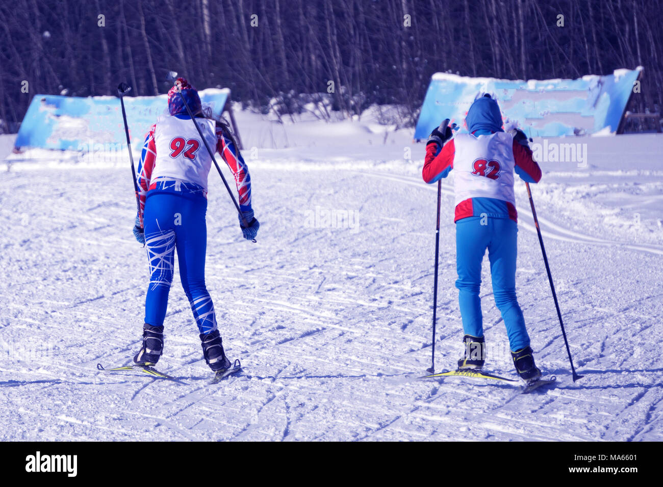Winter extreme sport of two young skiers on the ski run to the finish ...