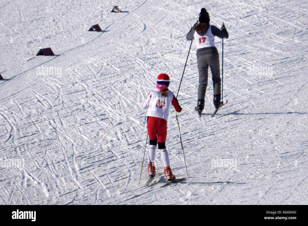 Full-length portrait of a happy skier standing with skis on the slope ...