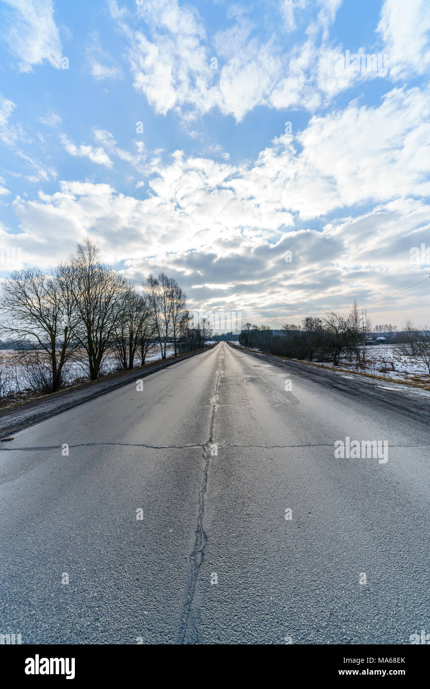 snowy winter road covered in deep snow with car tire tracks going in ...
