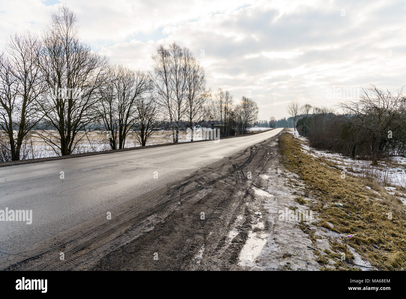 snowy winter road covered in deep snow with car tire tracks going in ...
