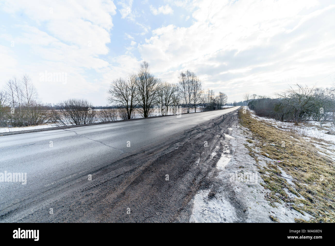 snowy winter road covered in deep snow with car tire tracks going in ...