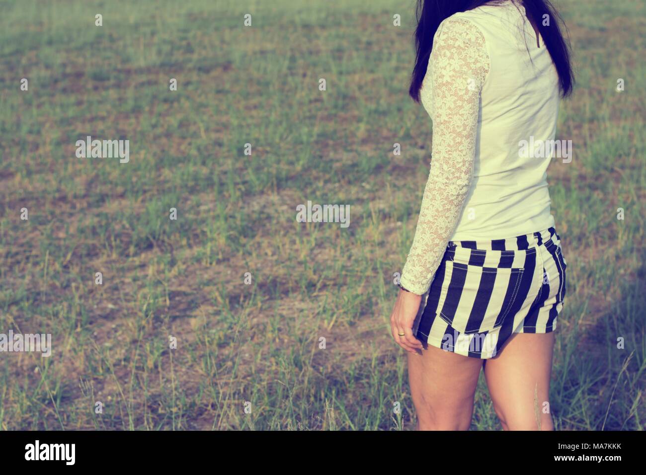 sad woman standing in grass field Stock Photo - Alamy