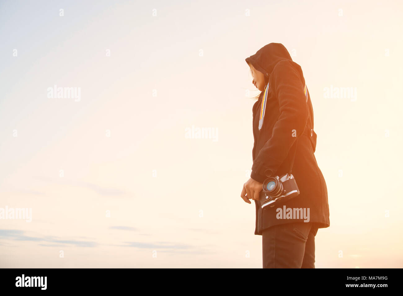 Young woman wearing black coat standing carry retro camera Stock Photo ...