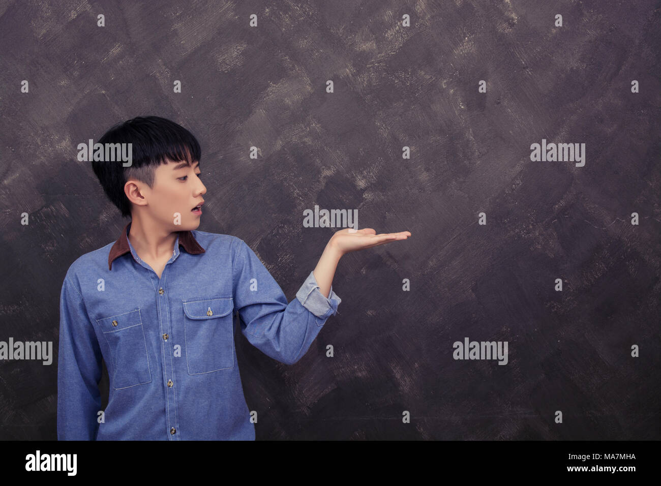 handsome young man standing against grunge background look at his left ...