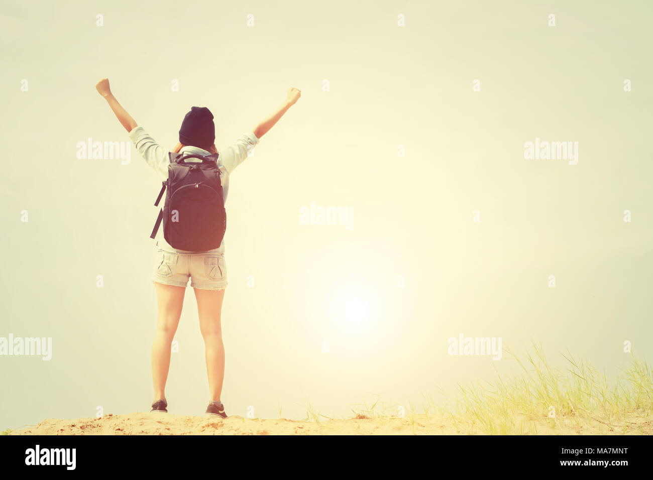 Young woman carrying backpack put her hands up ready to go Stock Photo ...