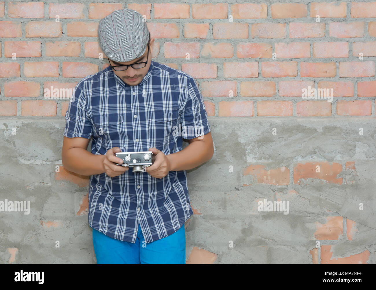 Handsome hipster guy standing in casual clothes in front of an urban ...