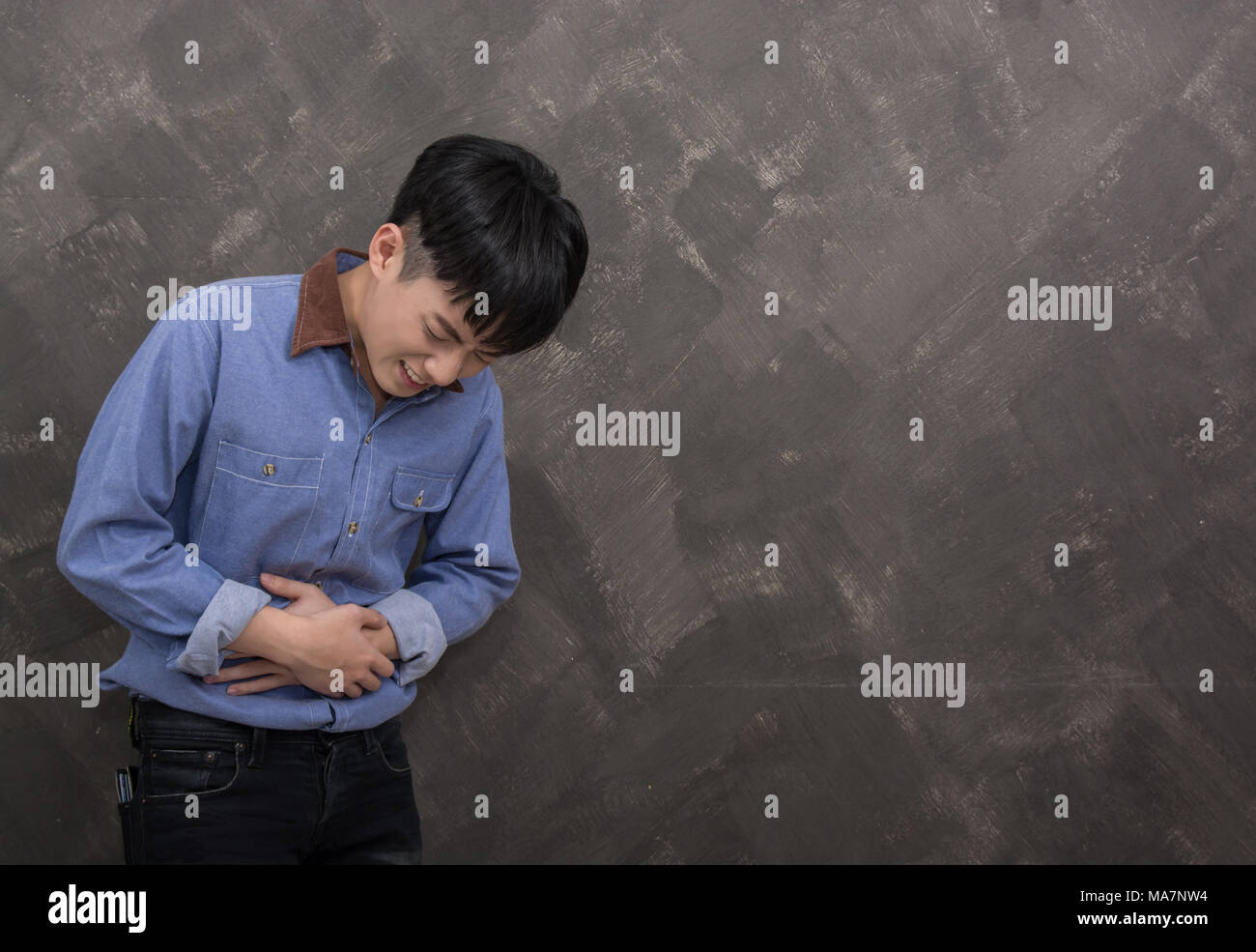 Young asian man suffer from severe stomachache Stock Photo - Alamy