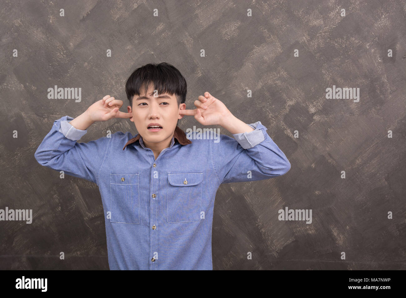 Young asian man disgusted young man plugging his ears to refuse ...
