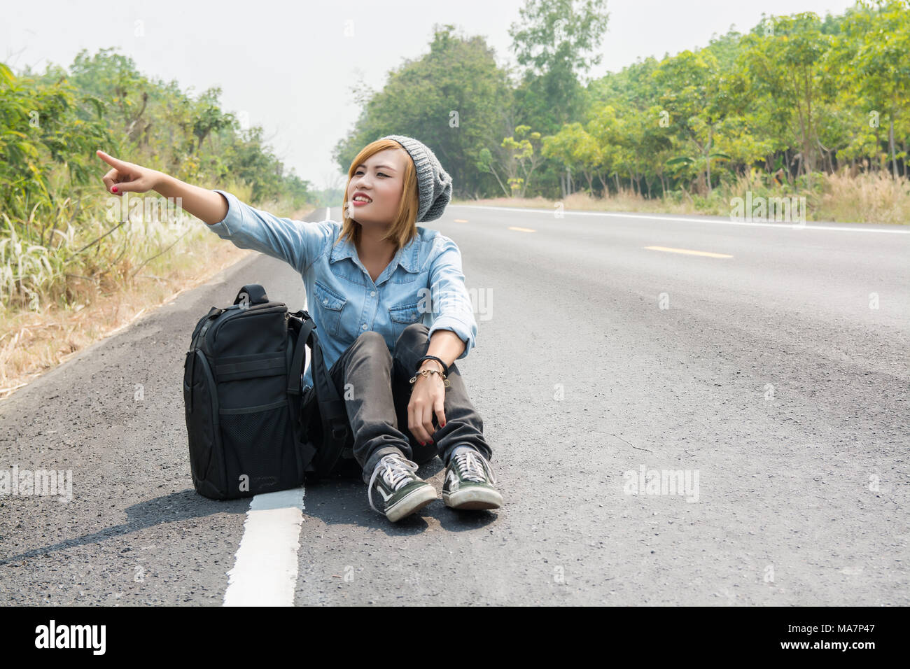 Hitchhiker sitting on roadside hi-res stock photography and images - Alamy