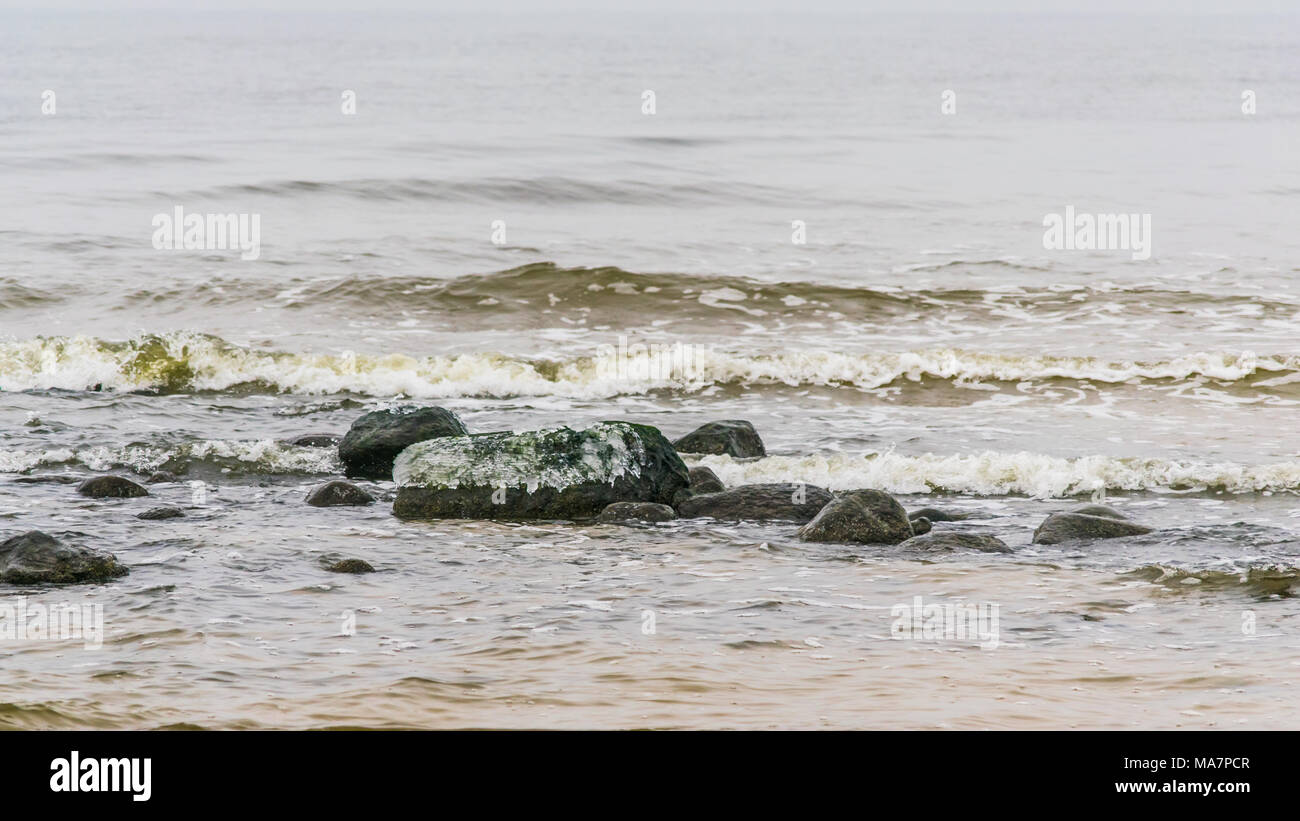 waves splash on frozen stone Stock Photo - Alamy